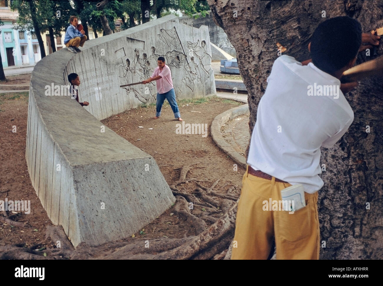Boys playing stickball in front of a monument to the revolution in a ...