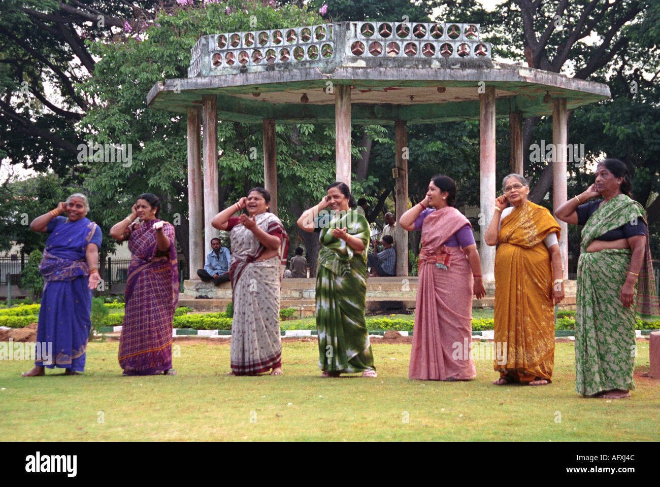 Women laughing into imaginary mobile phones at a laughter club in ...