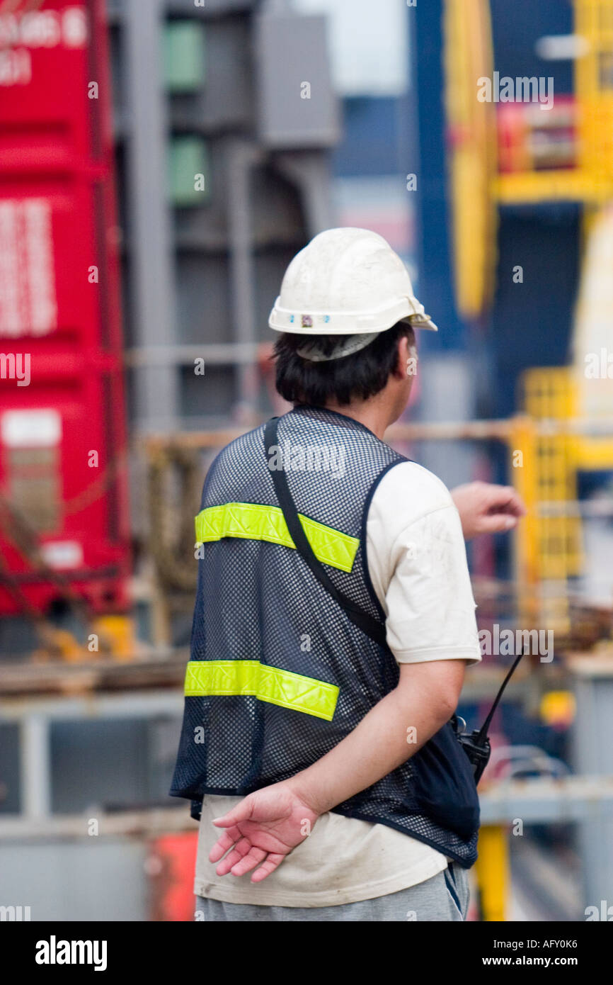 Container ship Dock worker Longshoreman watches as heavy lift crane ...