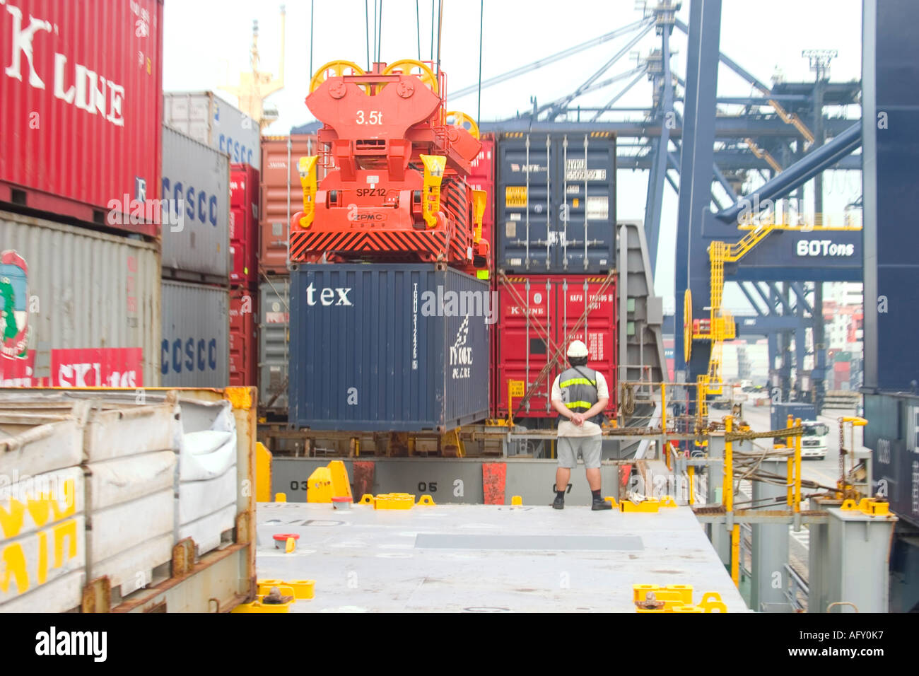 Container ship Dock worker Longshoreman watches as heavy lift crane ...