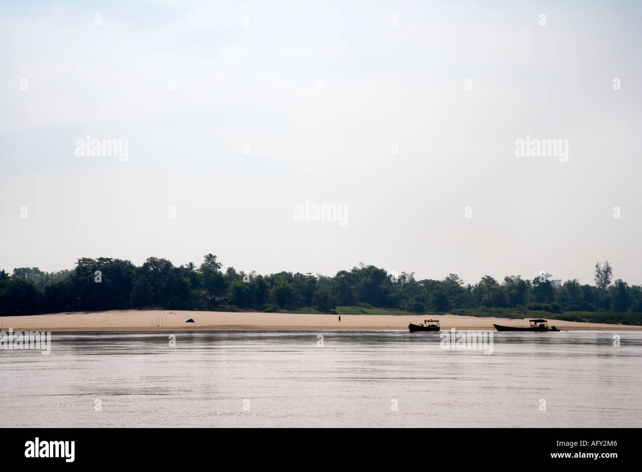 Beach and fishing boats lone figure, Don Daeng, Mekong River, Laos ...