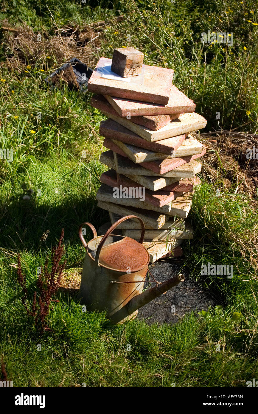 Allotment - rusty watering can and old tiles Stock Photo - Alamy