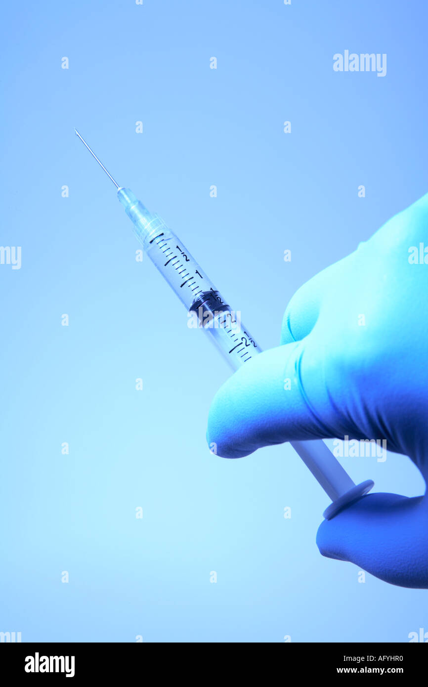 Doctors hand holding syringe Stock Photo - Alamy