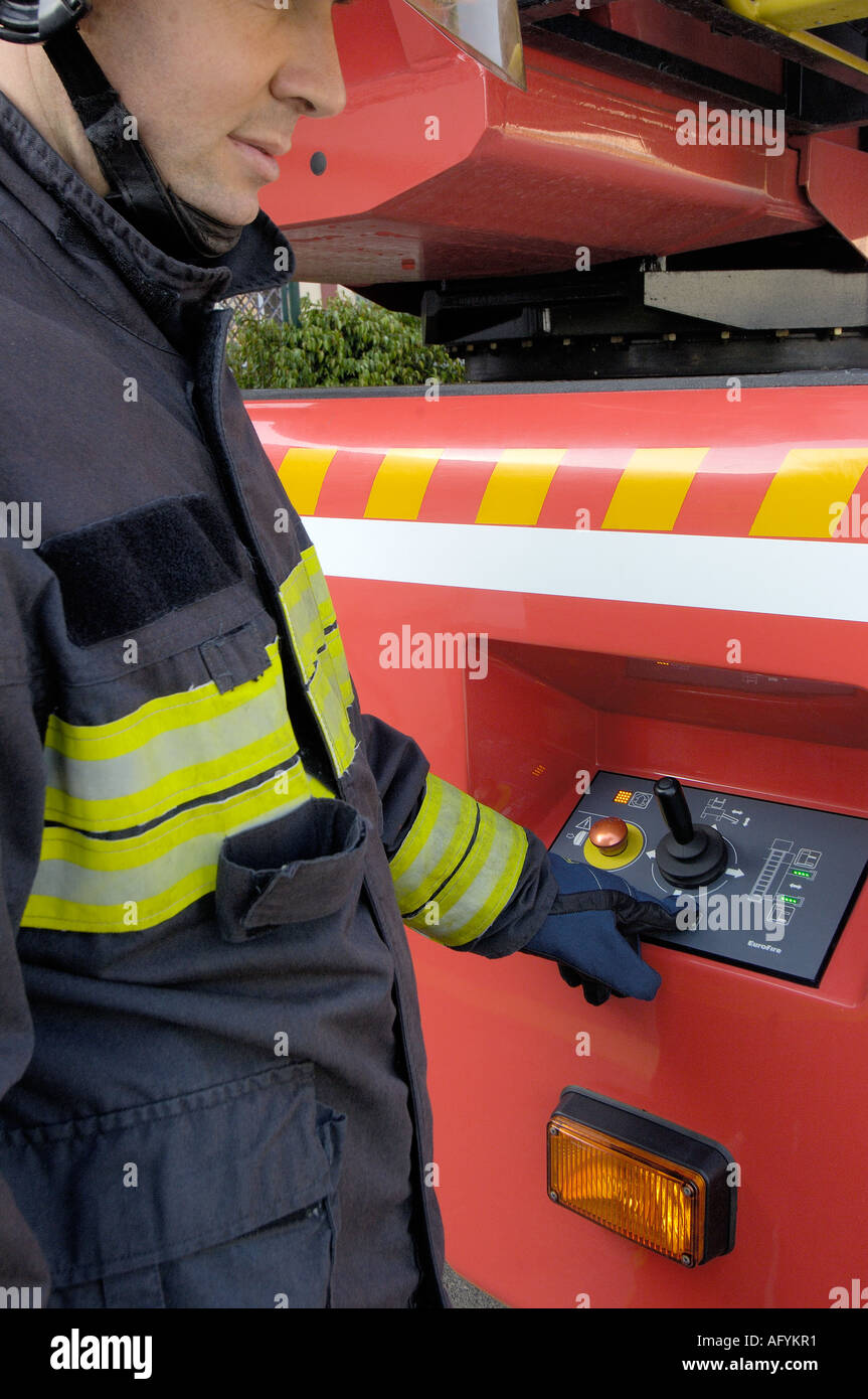 Fireman operating the ladder controls of the fire truck Stock Photo - Alamy