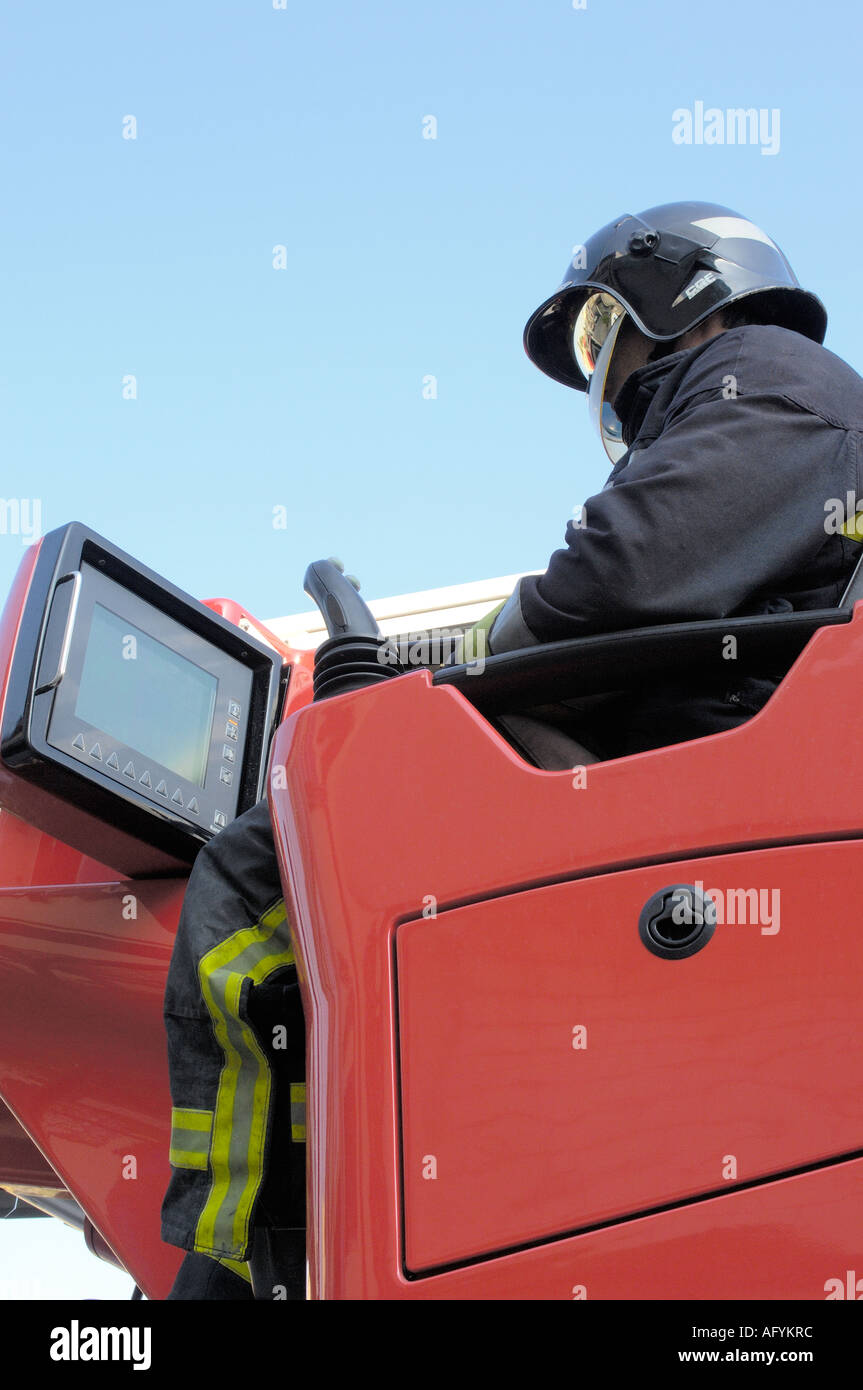 Fireman operating the ladder controls of the fire truck Stock Photo - Alamy