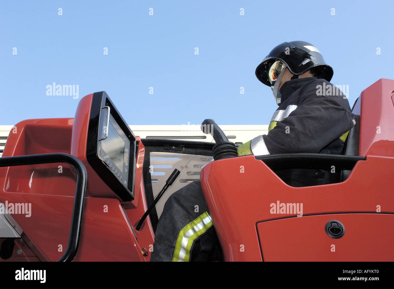 Fireman operating the ladder controls of the fire truck Stock Photo - Alamy