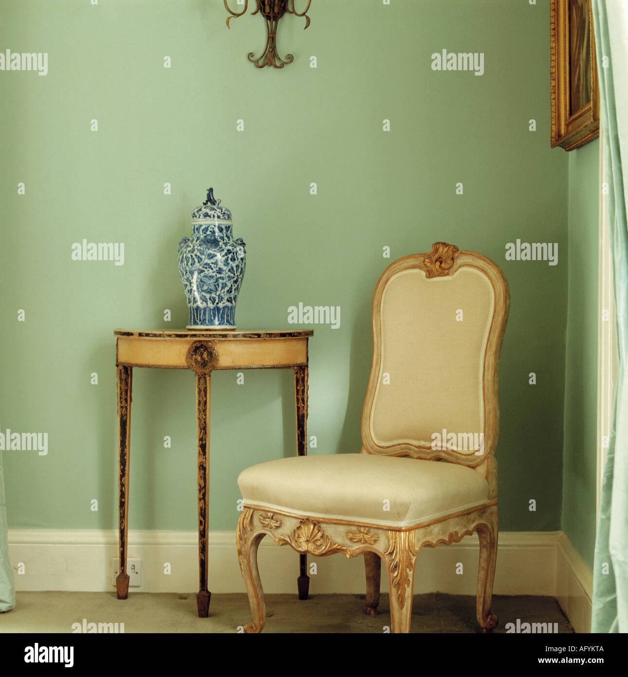 Chair and console in green painted interior Stock Photo - Alamy