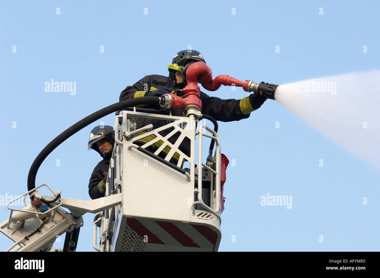 Firemen using water cannon Stock Photo - Alamy