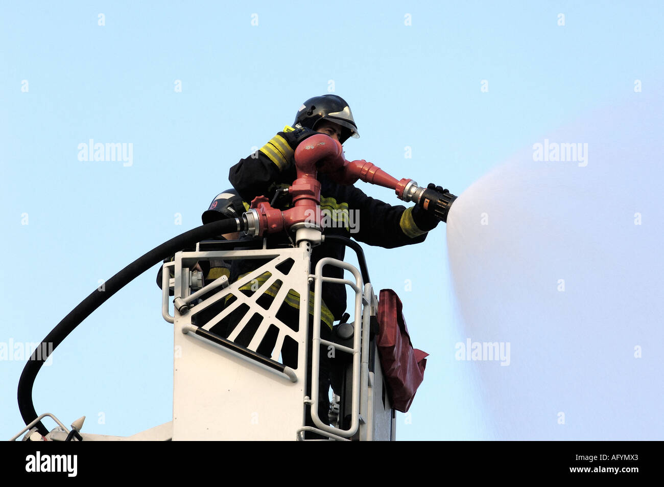 Firemen using water cannon Stock Photo - Alamy