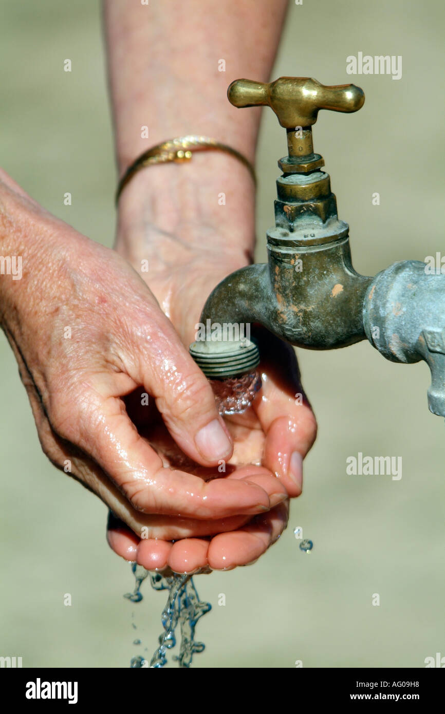 washing hands at a standpipe with a brass tap outlet at time of water ...