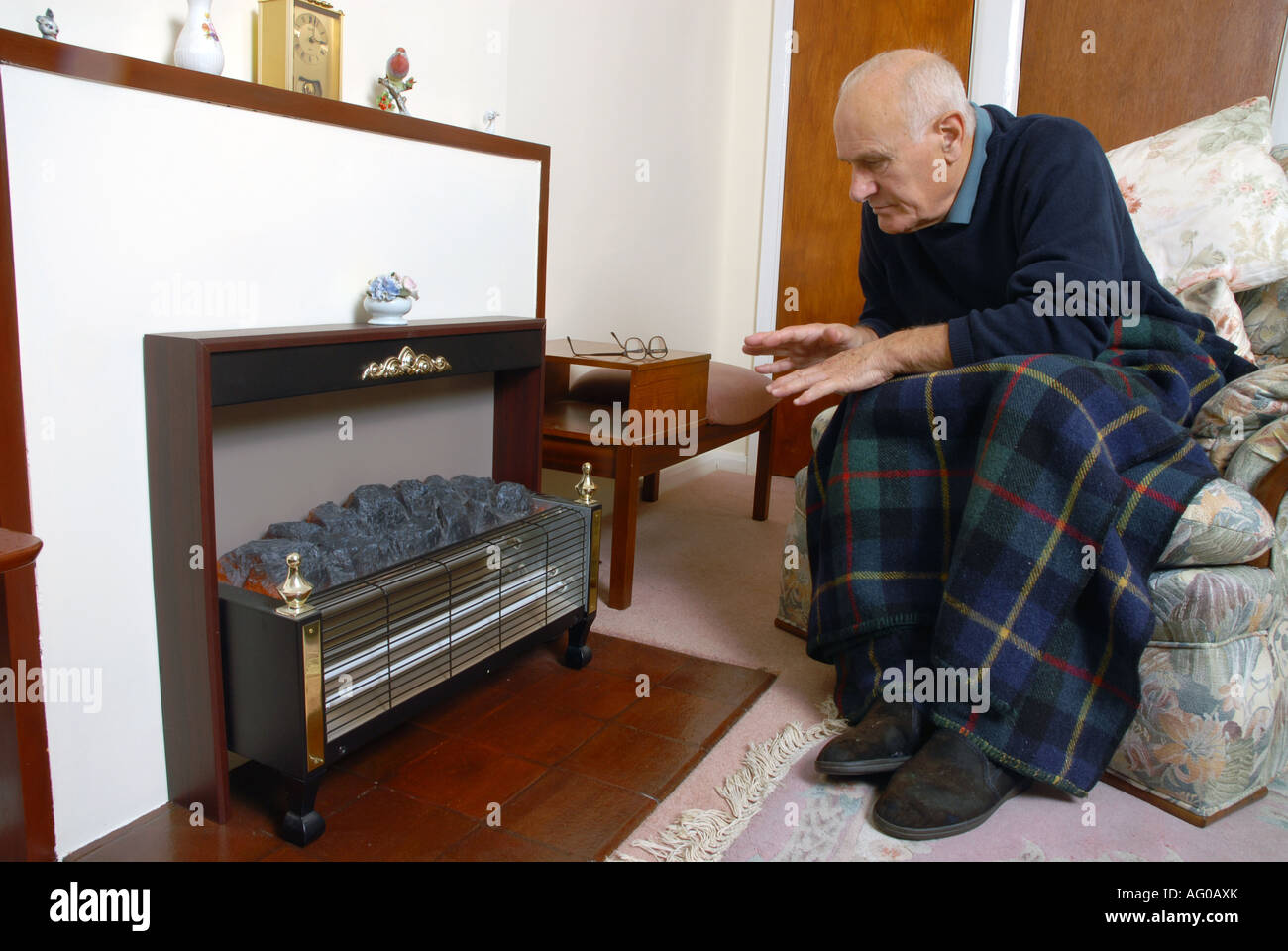 A elderly man sitting infront of his electric fire Stock Photo - Alamy