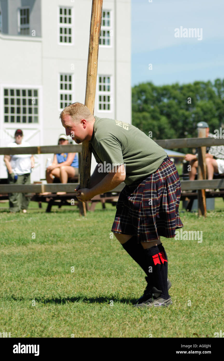 Man getting to toss "the caber" at a Highland Games gathering Stock ...