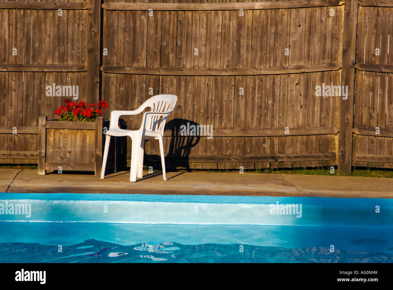 White deck chair by swimming pool Stock Photo - Alamy