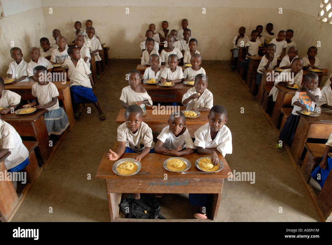 Schoolchildren eat with their hands at lunch time in a primary ...