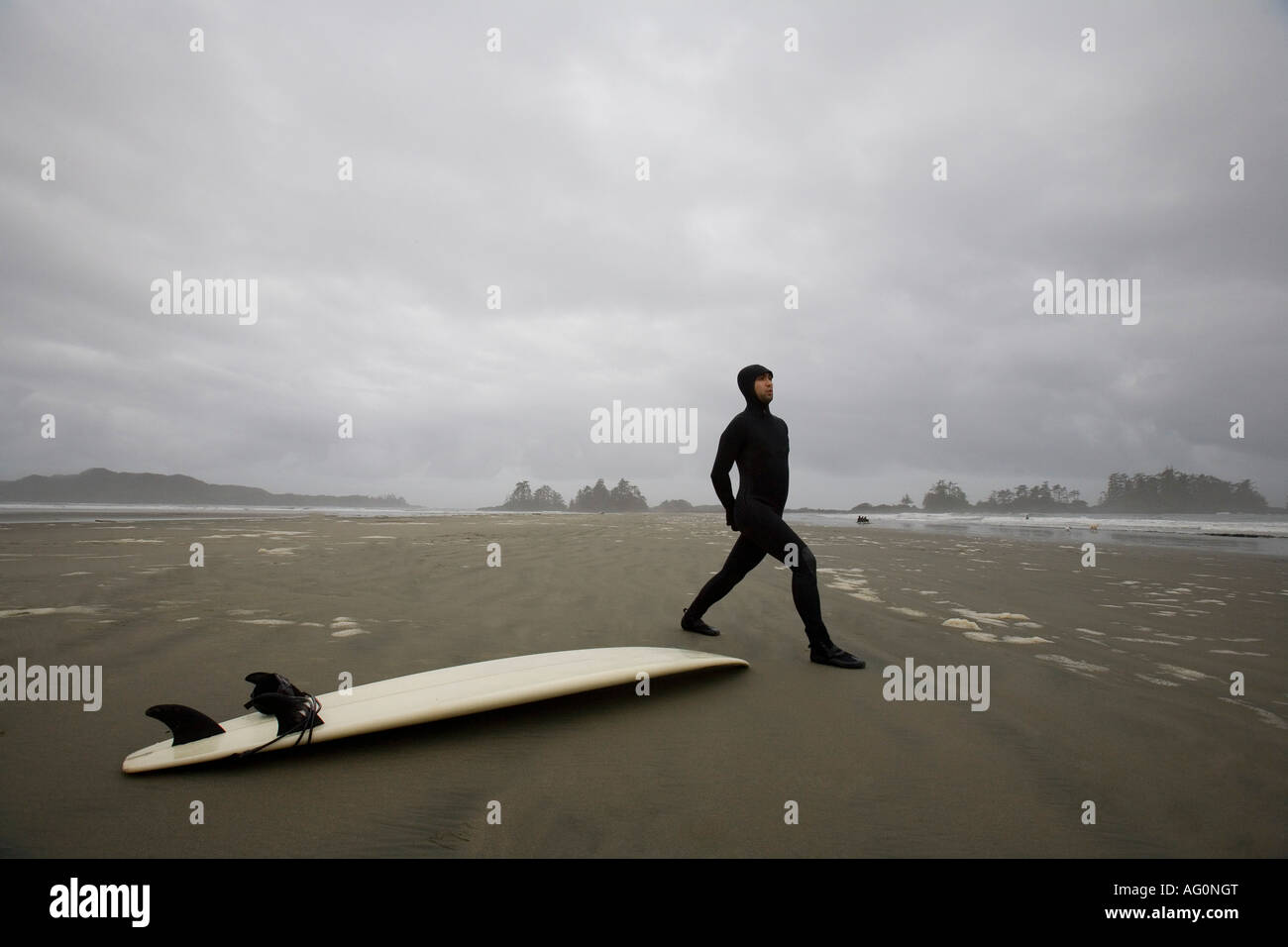 Surfer stretching on the beach Stock Photo - Alamy