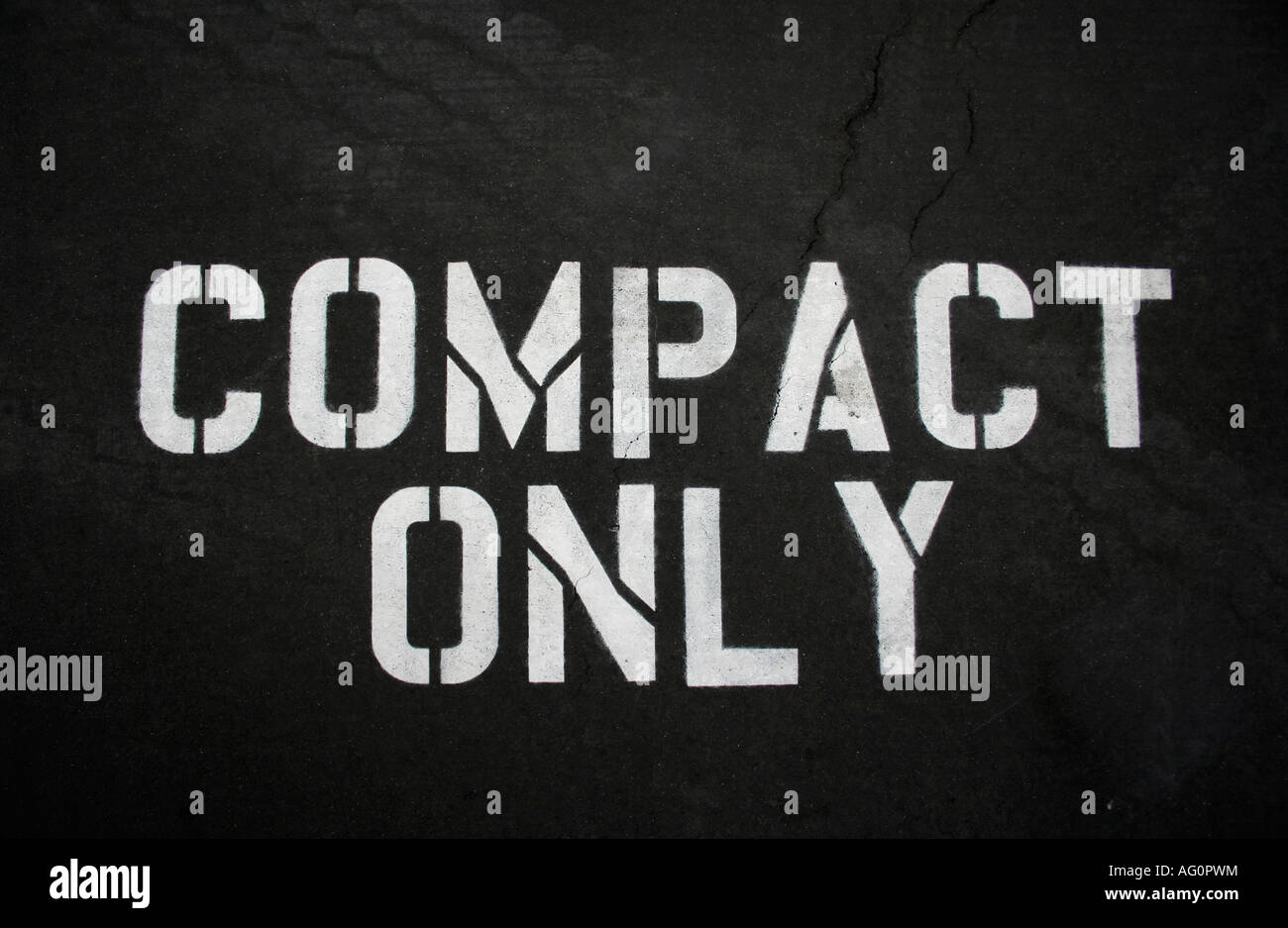 COMPACT ONLY white letters painted on black ashpalt Stock Photo - Alamy