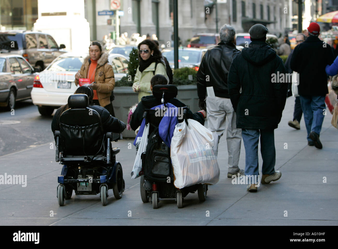 disabled people in motorised wheelchairs out shopping drive along ...