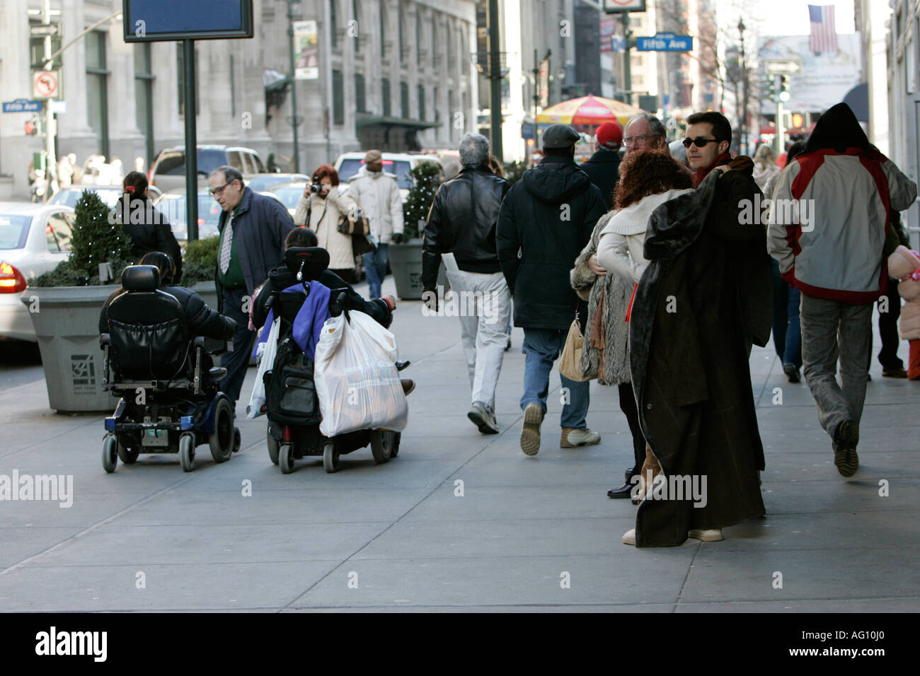 disabled people in motorised wheelchairs out shopping drive along ...