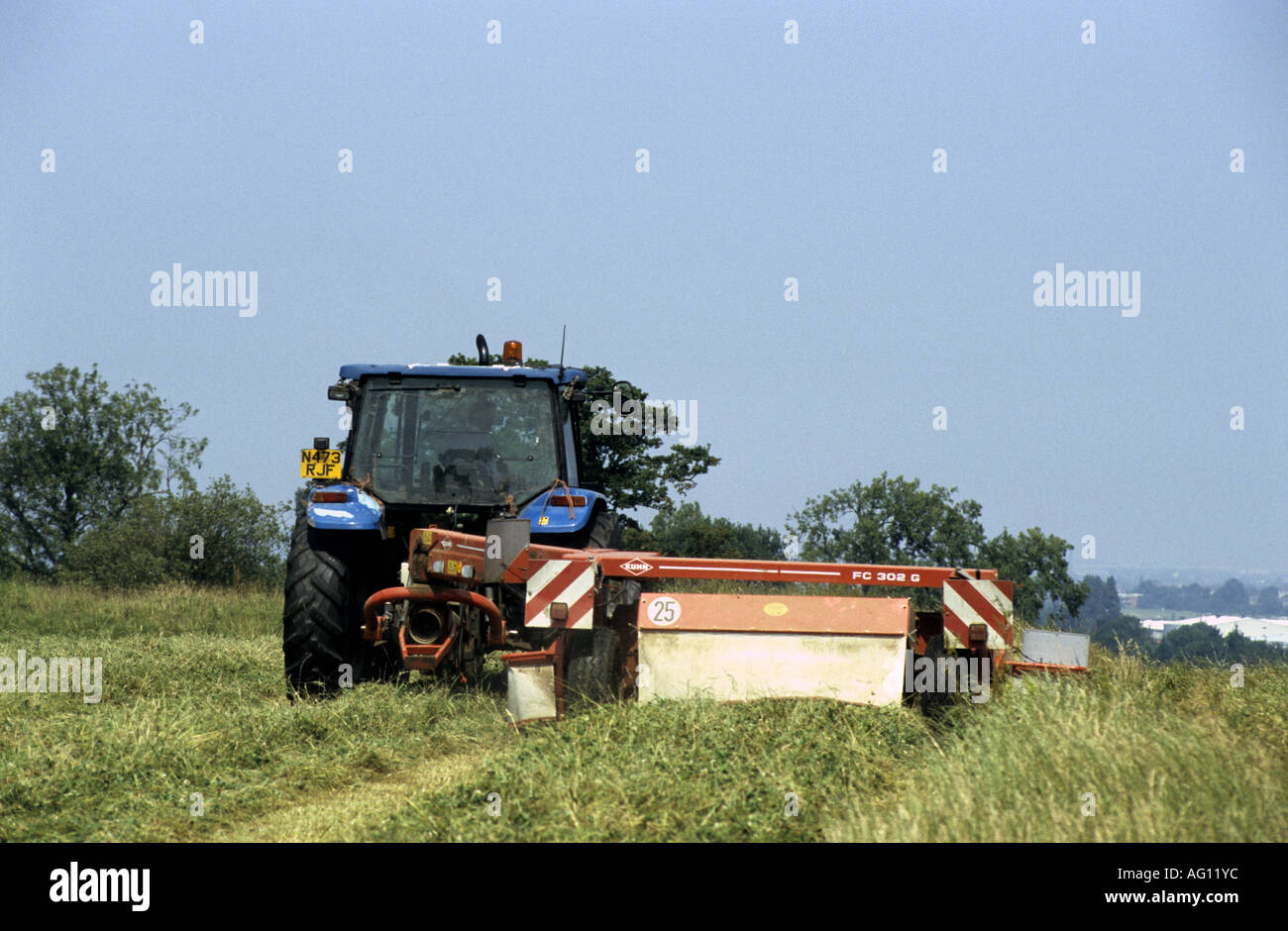 New Holland tractor cutting hay field, Warwickshire, England, UK Stock ...