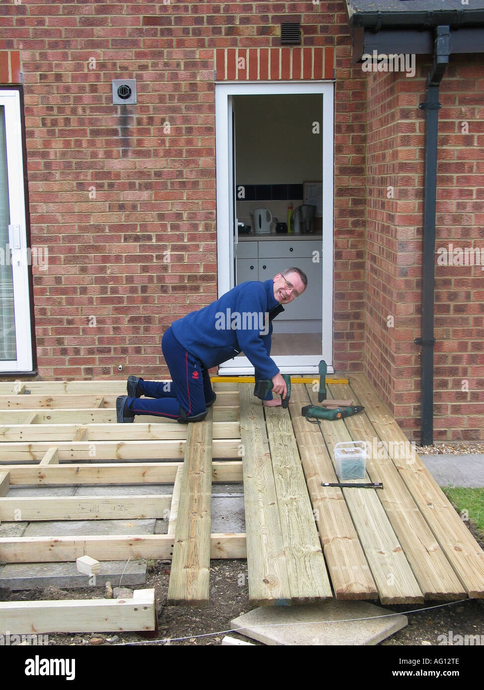 Man Building Deck in Back Garden Stock Photo - Alamy