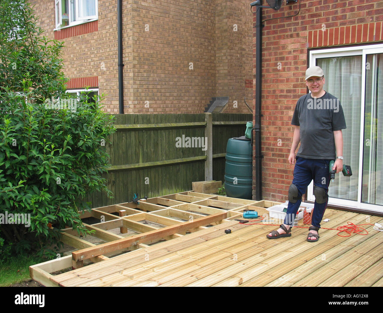 Man Building Deck in Back Garden Stock Photo - Alamy