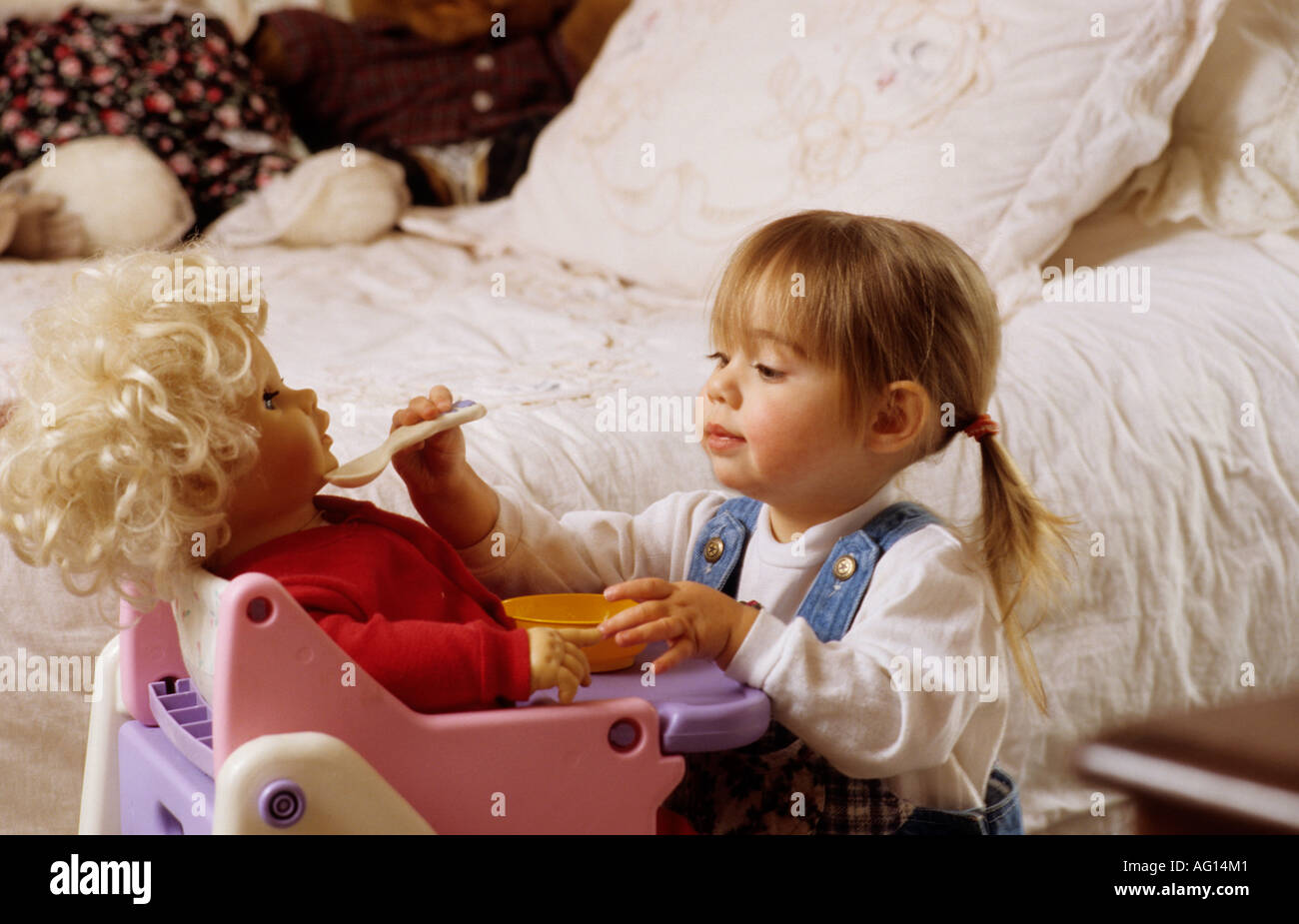 Little girl feeding doll Stock Photo - Alamy