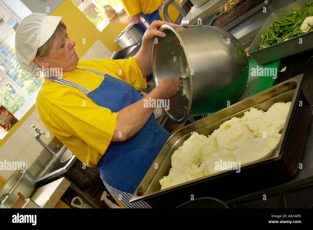 school dinners. School cook using fresh produce used to produce healthy ...