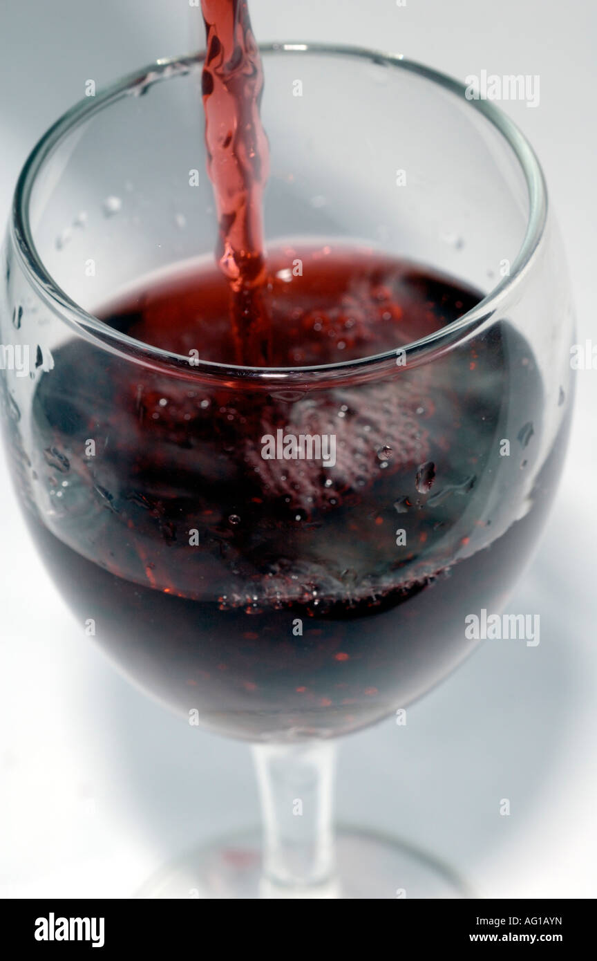 Red wine flowing into wine glass Stock Photo - Alamy