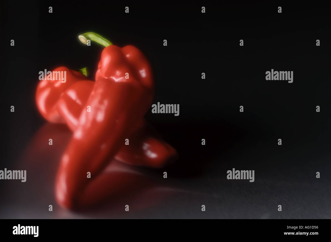 Red peppers dark background landscape shot. Two small red chilli ...