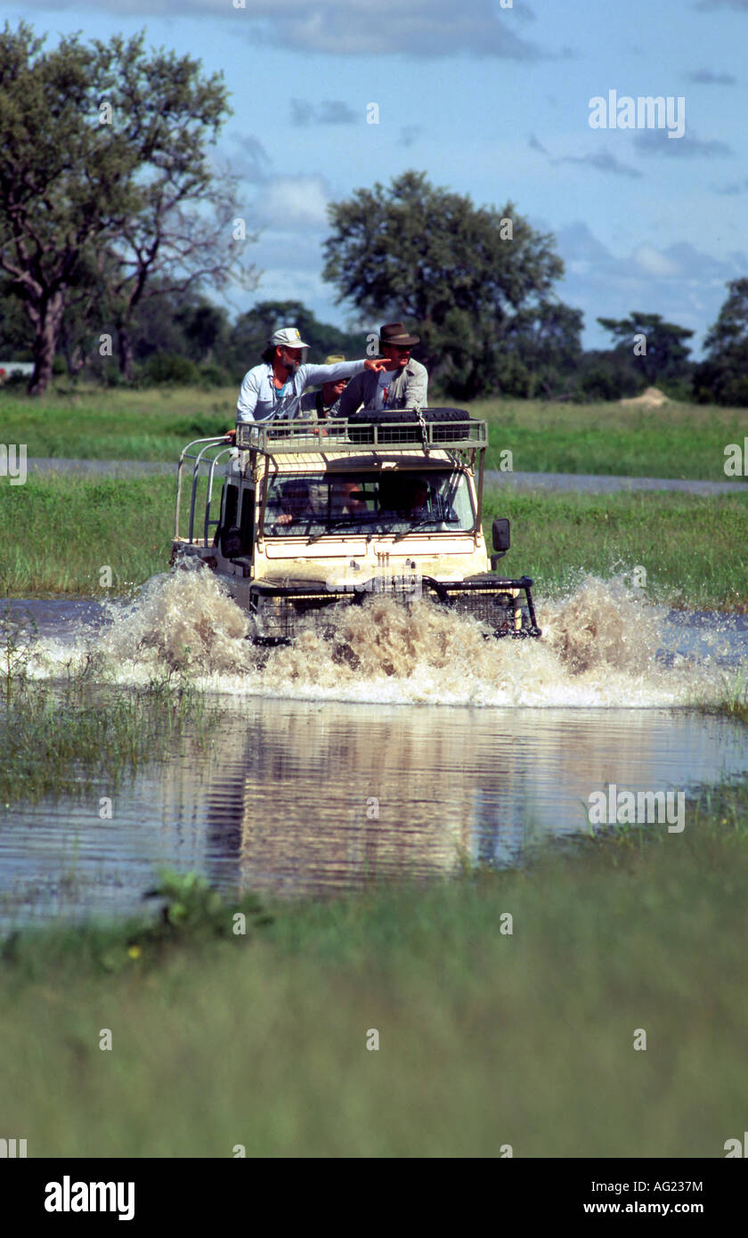 a group of men crossing a river in a landrover Stock Photo - Alamy