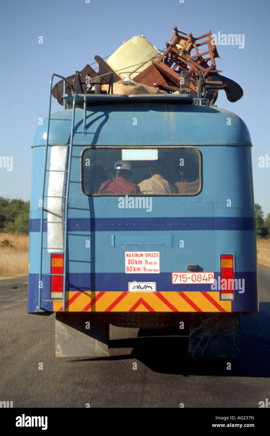 The rear view of a passenger bus traveling through a rural area of ...