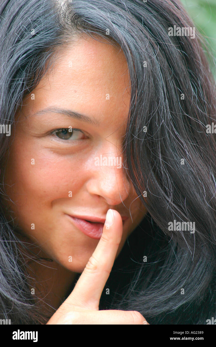 Black haired girl saying shhh Stock Photo - Alamy