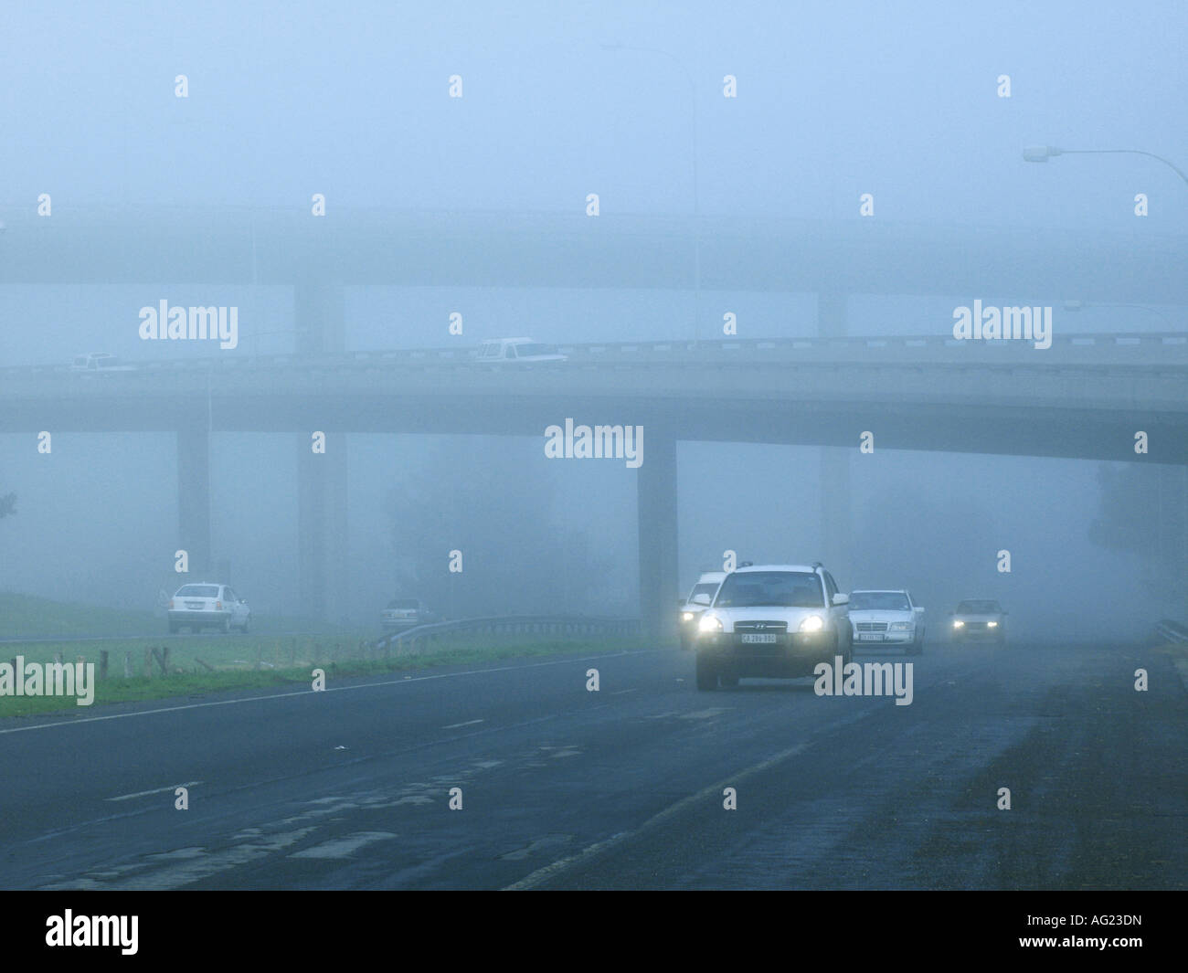 A thick mist covers the busy highway Cars turn on headlights for better ...