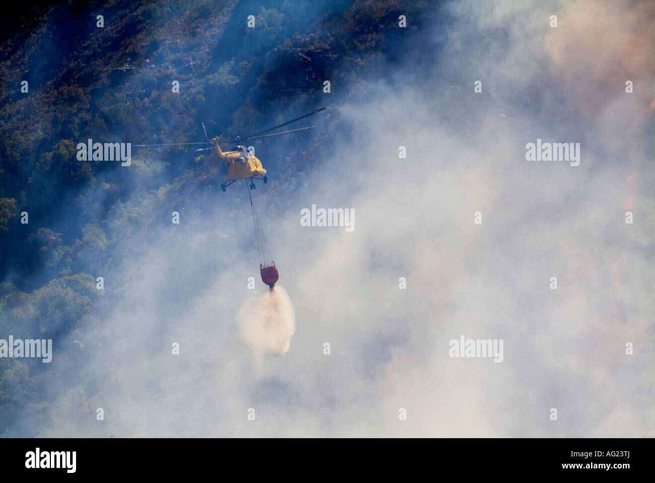 A helicopter water bombing mountain bush fire Stock Photo - Alamy