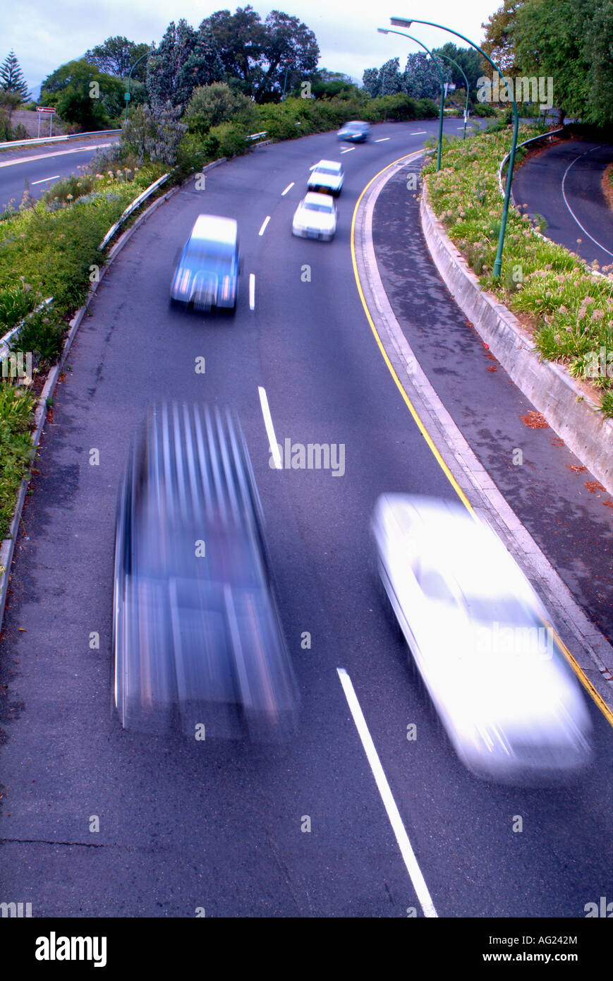 Cars speeding around a bend on the highway Stock Photo - Alamy