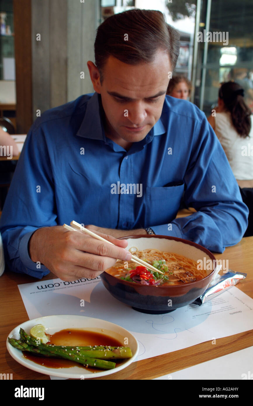 Man Eating Meal in a Restaurant Pan Asian Food Dish Eating noodles ...
