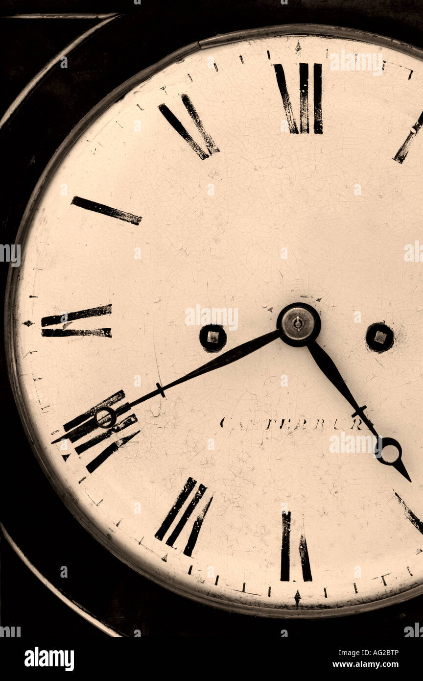 Close cropped image of an antique clock dark and grainy sepia toned ...