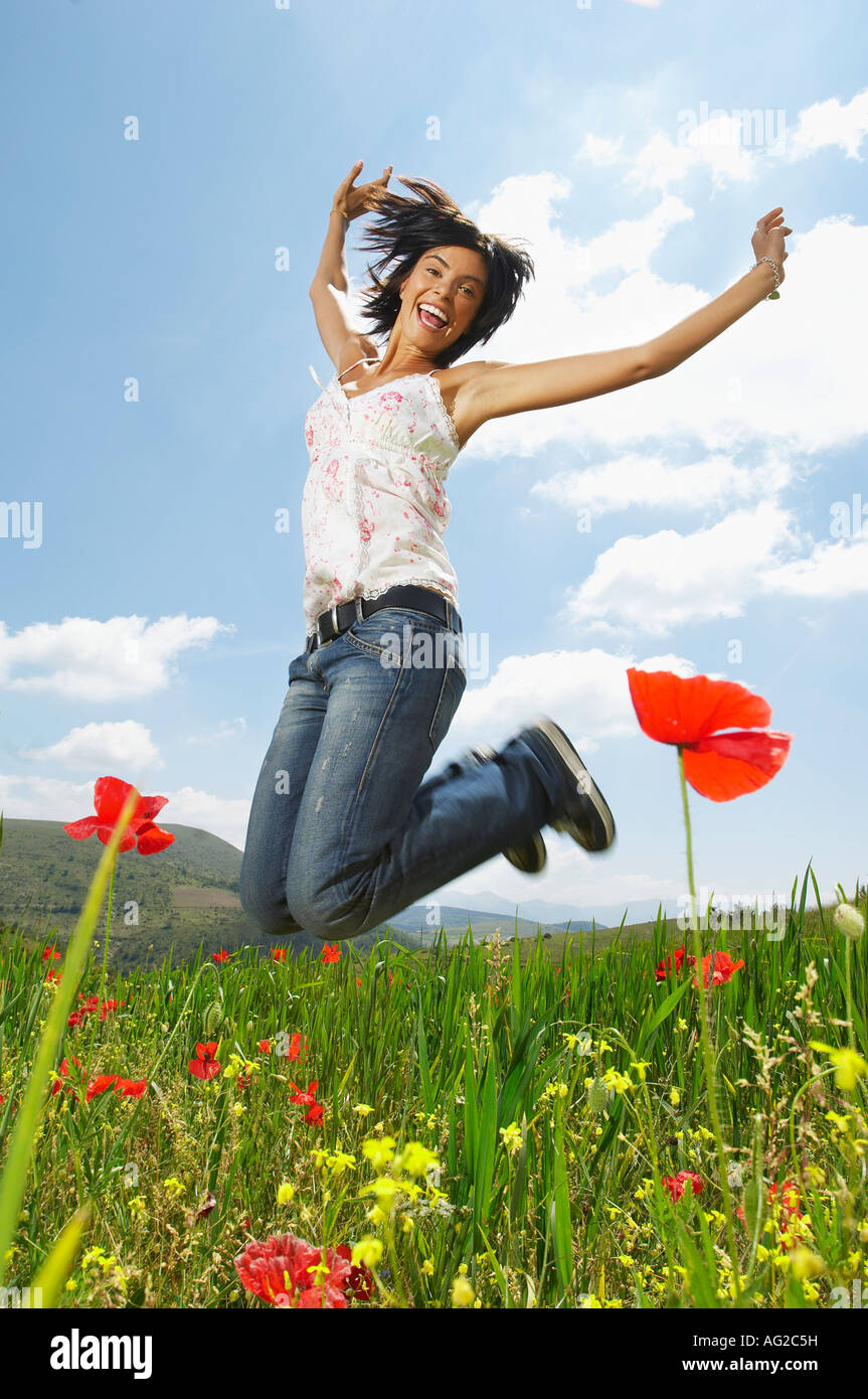 Woman jumping for joy in mountain meadow, portrait Stock Photo - Alamy