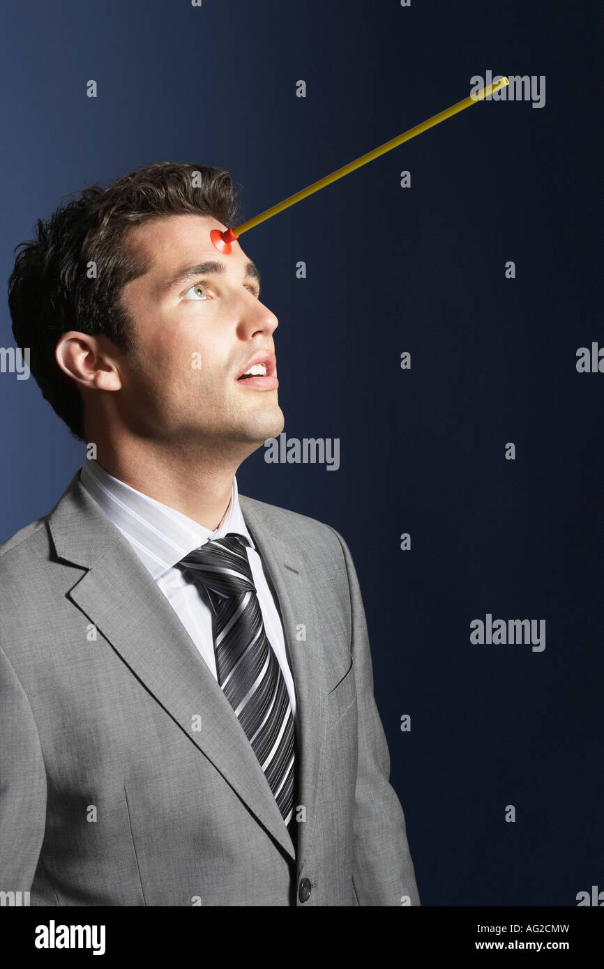 Man with toy arrow in forehead against dark background Stock Photo - Alamy