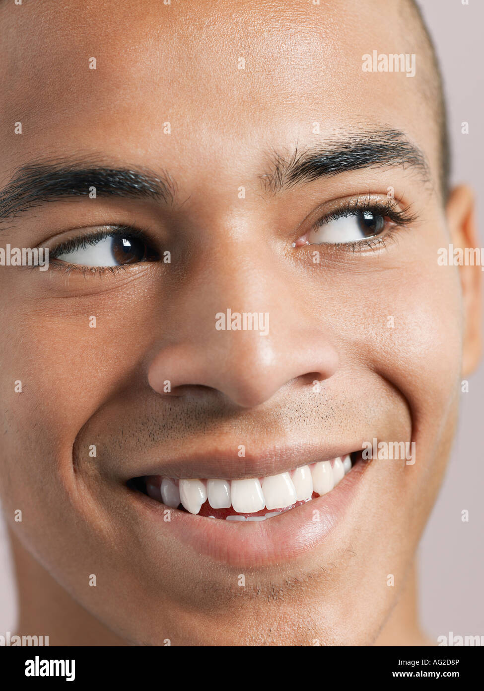 Young man looking aside and smiling, close-up of face Stock Photo - Alamy
