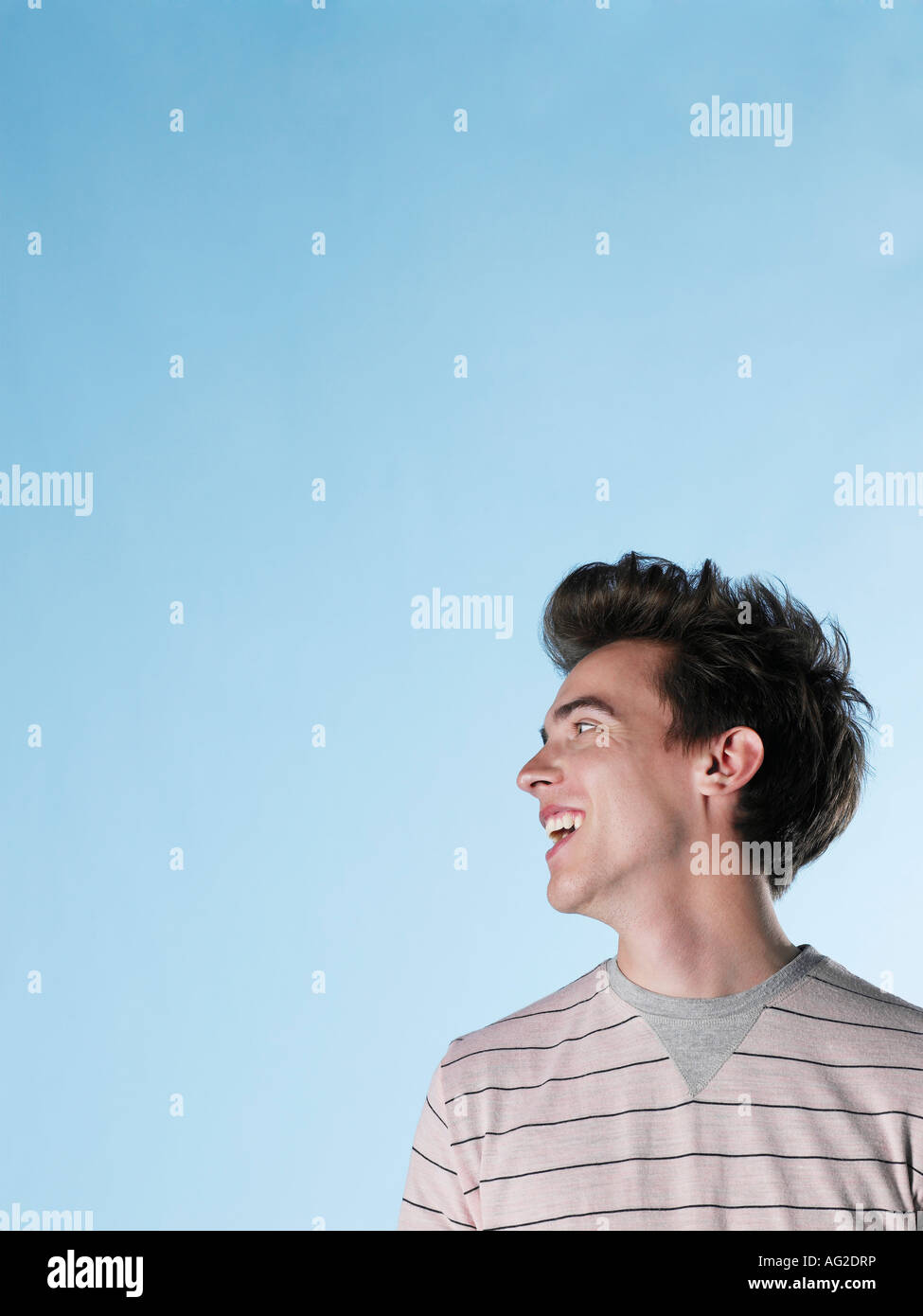Young man looking over shoulder and laughing Stock Photo - Alamy