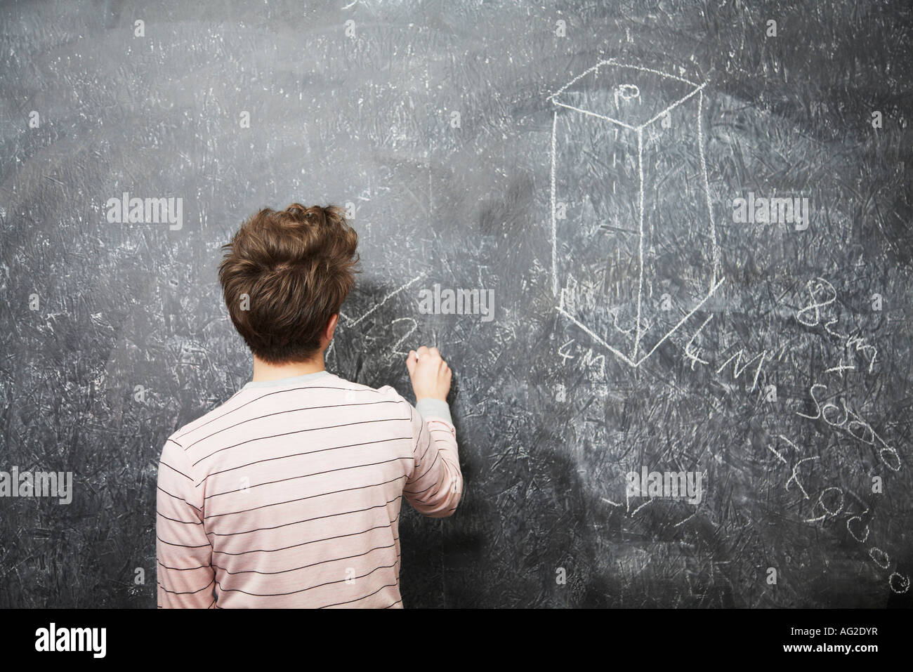 Young man writing on blackboard, back view Stock Photo - Alamy