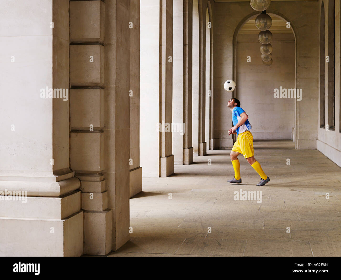 Soccer player bouncing ball off head in portico Stock Photo - Alamy