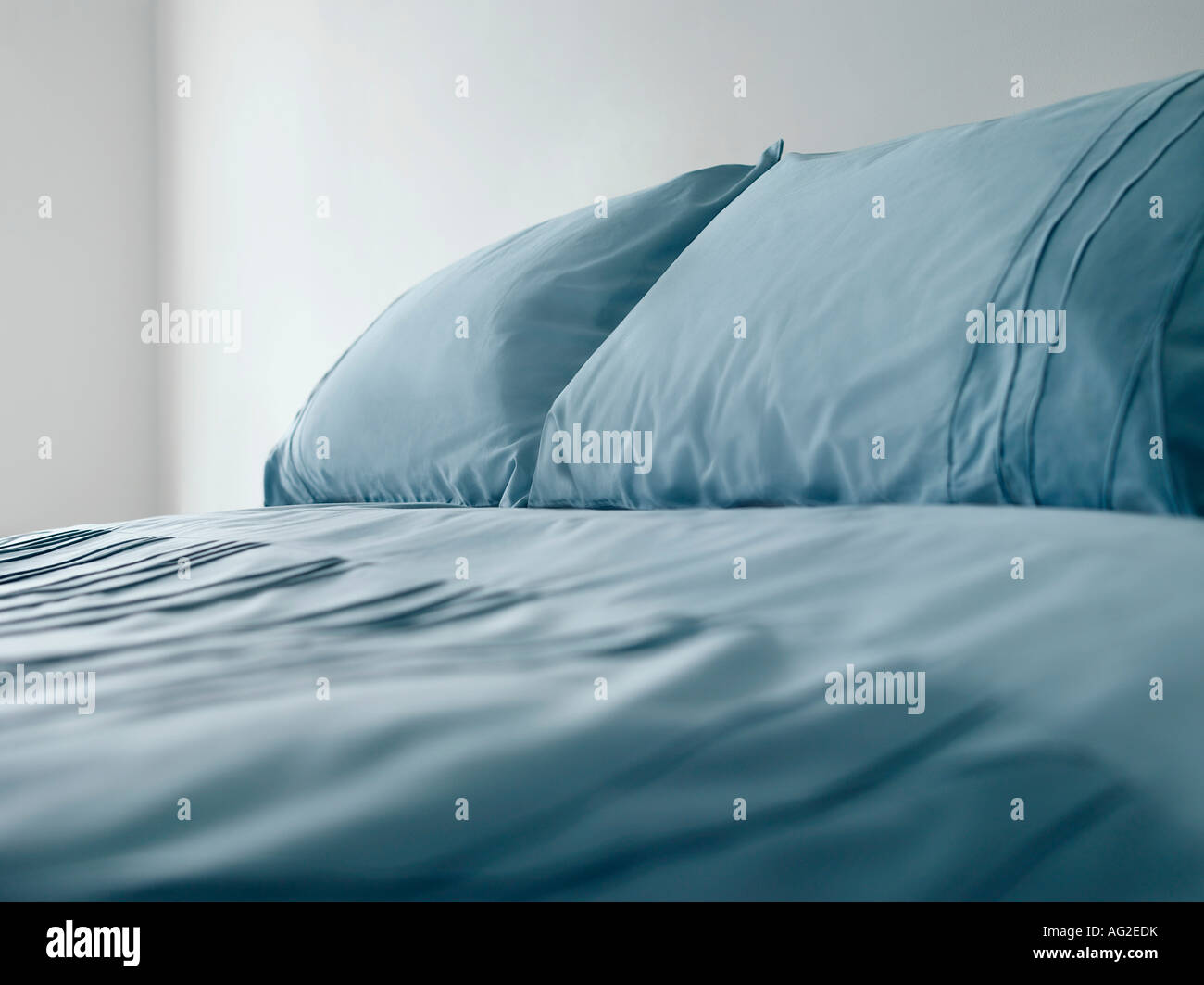 Bed with blue linen Stock Photo - Alamy