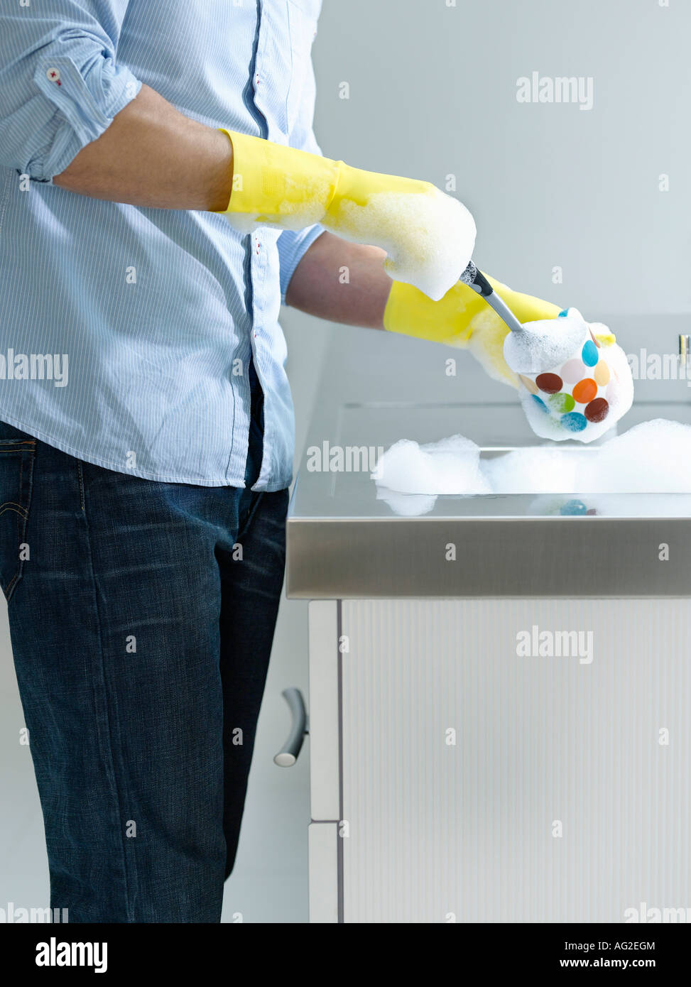 Man doing washing up at kitchen sink, mid section, side view Stock ...