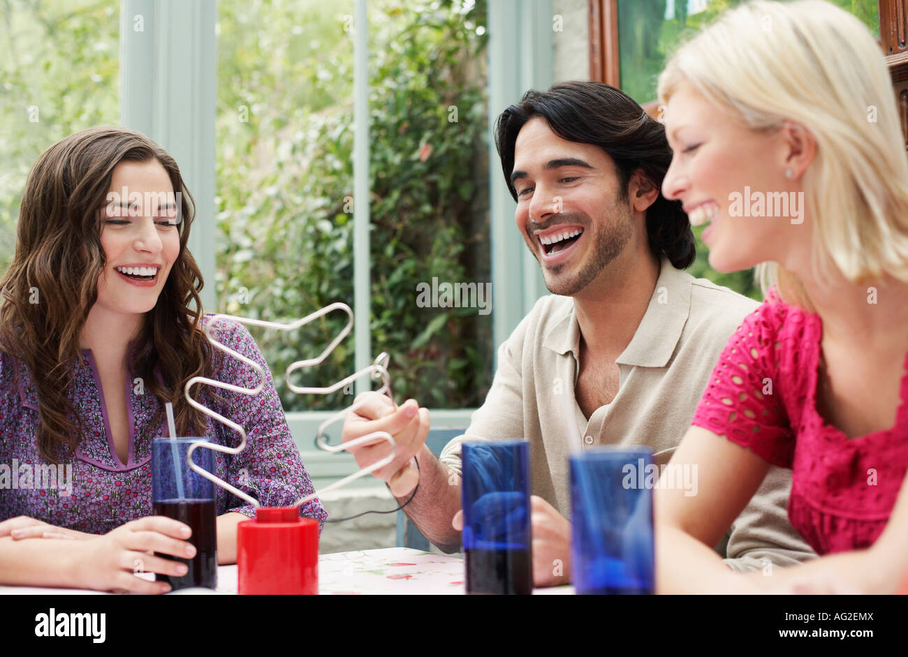 Group of young people sitting at verandah table Stock Photo - Alamy