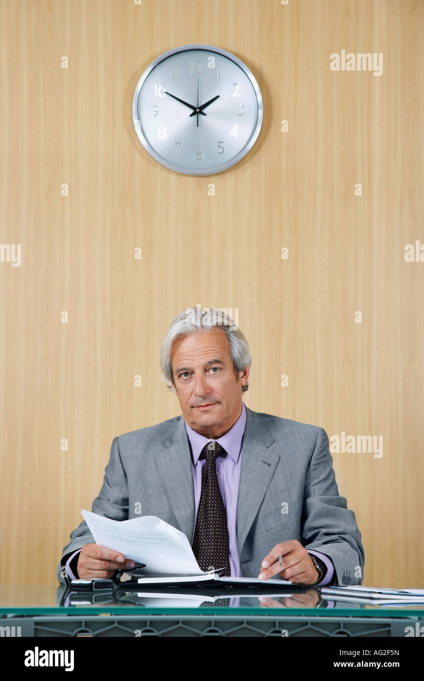 Business man holding papers in office Stock Photo - Alamy