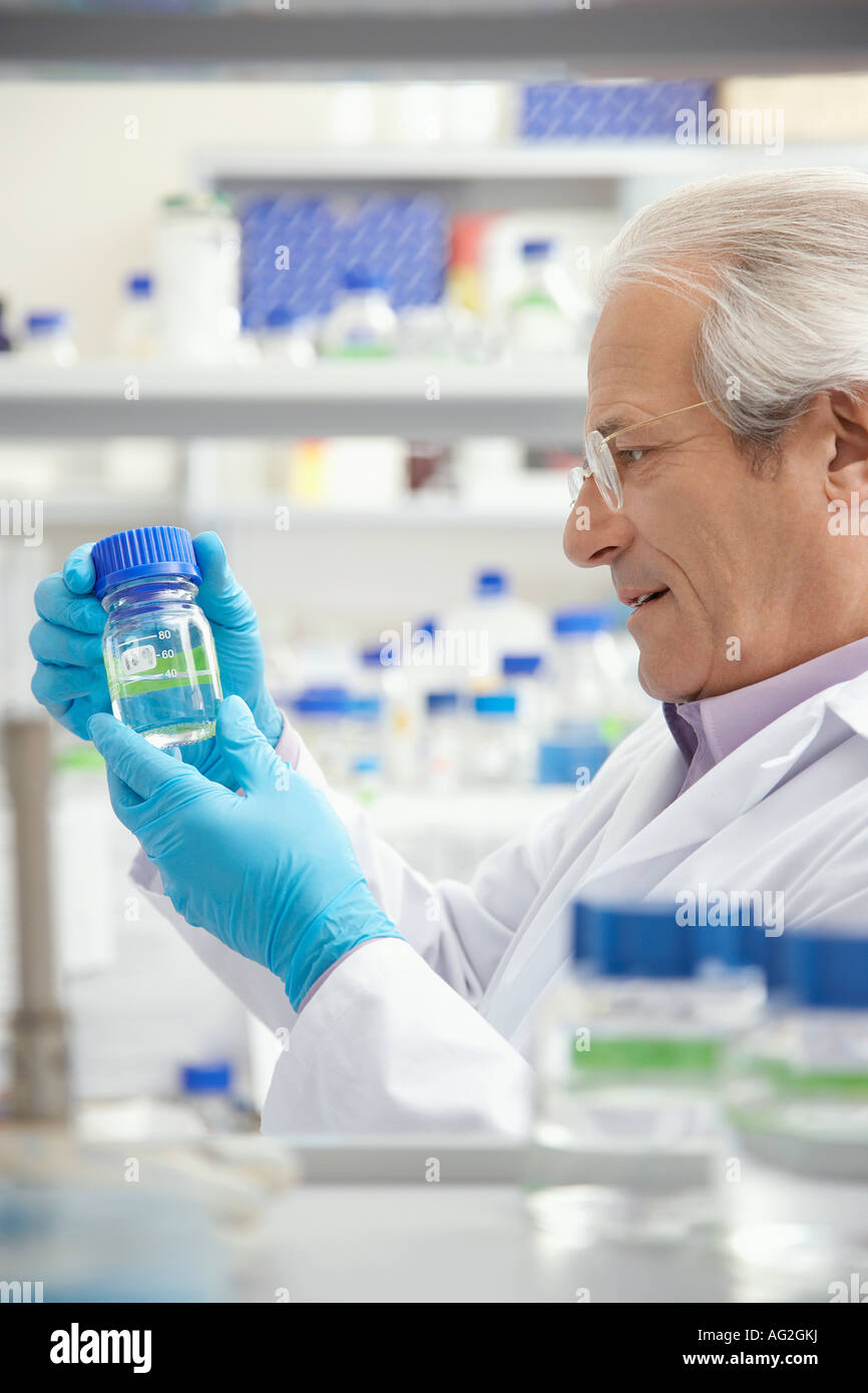 Scientist looking at specimen bottle in laboratory Stock Photo - Alamy