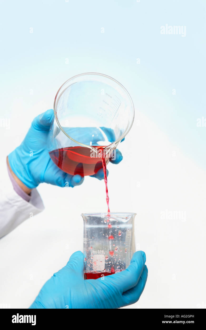 Scientist pouring red liquid into beaker, close-up of hands Stock Photo ...