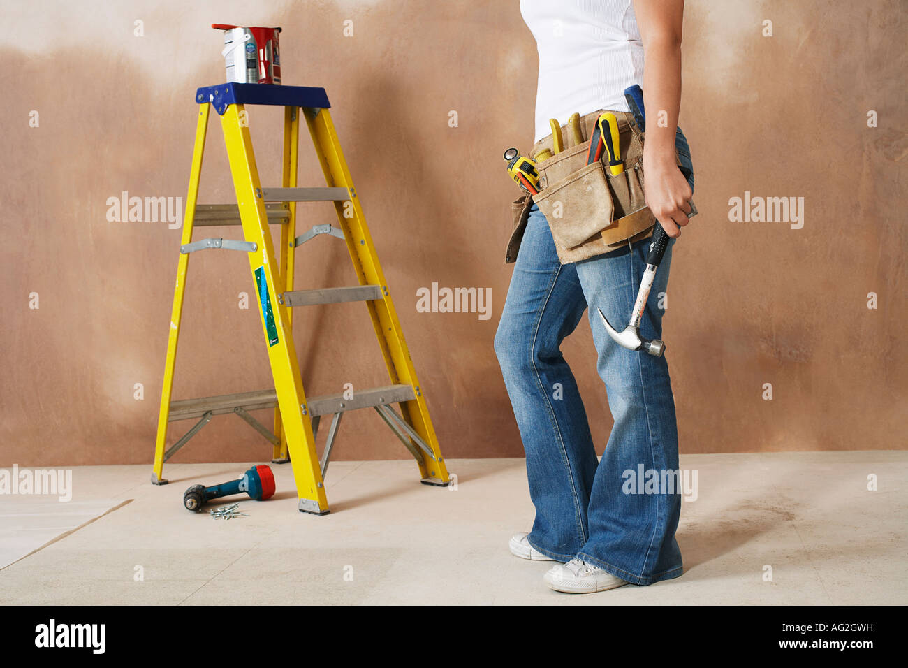 Woman with toolbelt and hummer, low section Stock Photo - Alamy